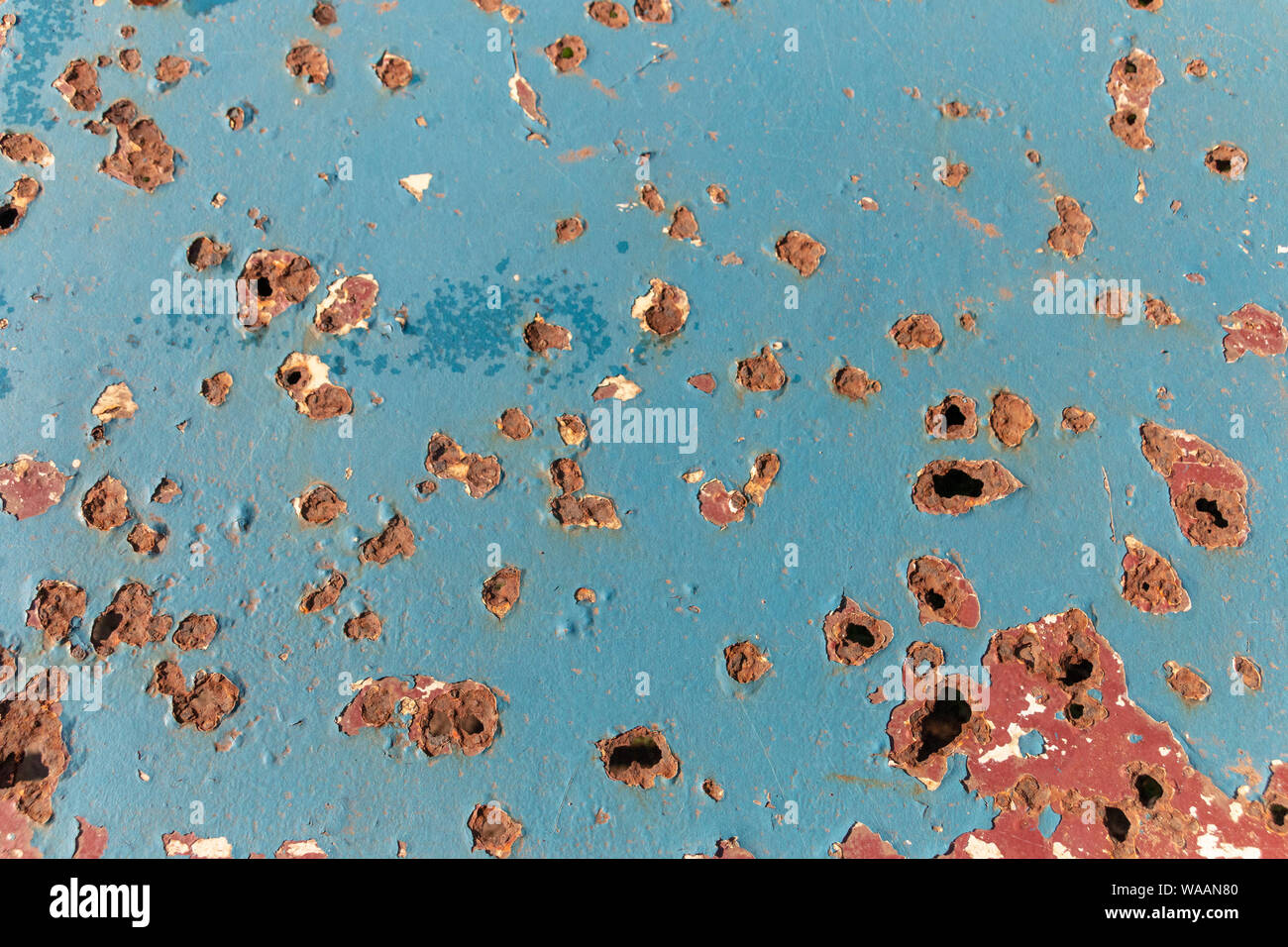 A close up view of a metal table with lots of rusted holes all over it ...