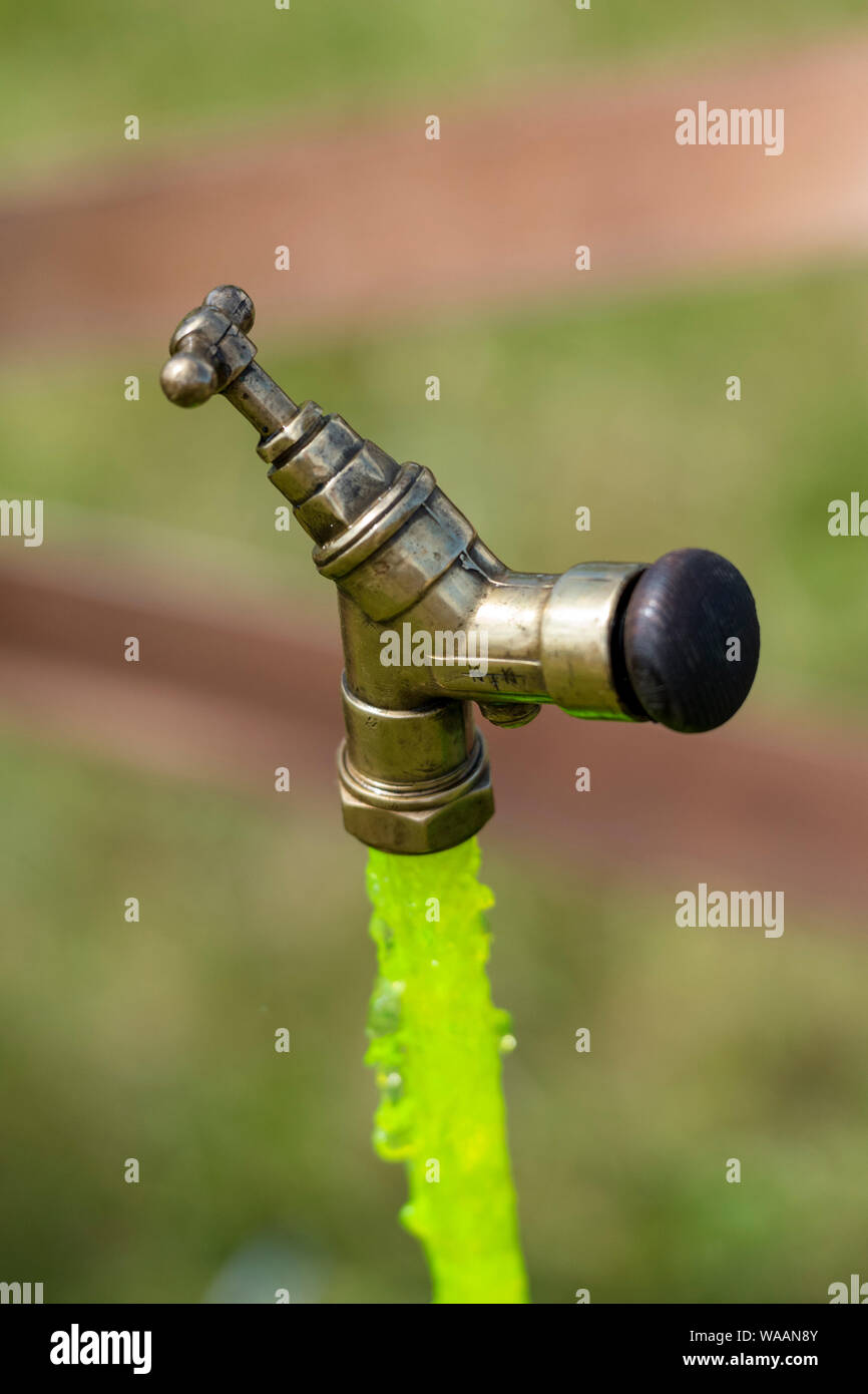 an old fashioned style brass outside tap running water from spout Stock ...
