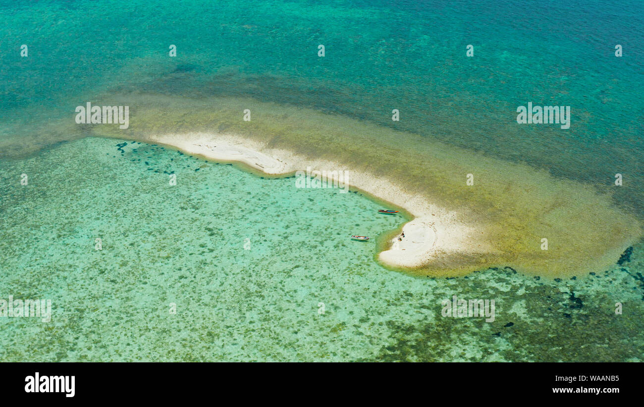 Small sandy beach on a coral atoll in turquoise water, aerial view ...