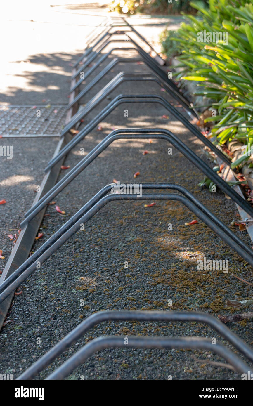 A close up view of a metal bicycle rack on a tar drive way Stock Photo ...