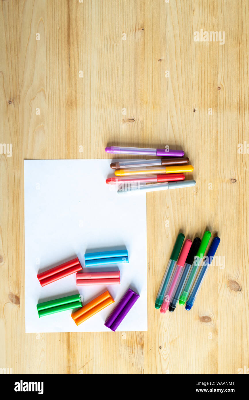 Overview of wooden table background with blank paper and crayons Stock ...