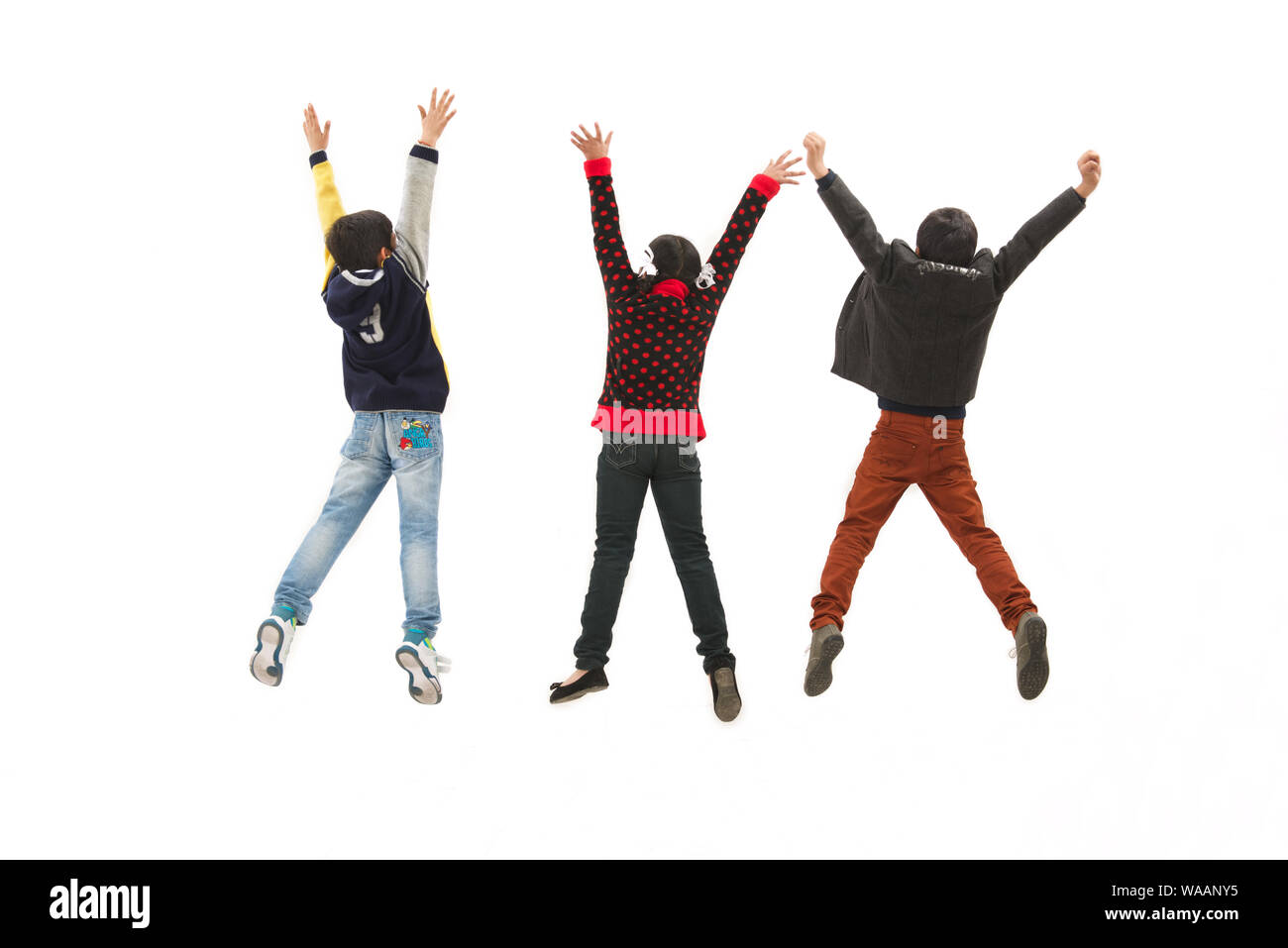 Rear view of three children jumping in air Stock Photo - Alamy