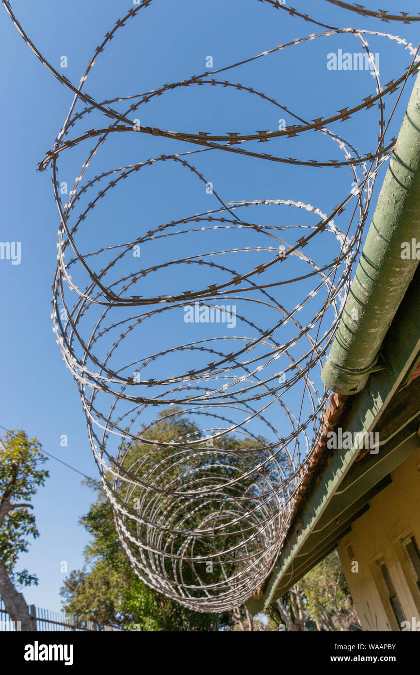 A close up view of large metal barbed wire on top of a old buildings ...