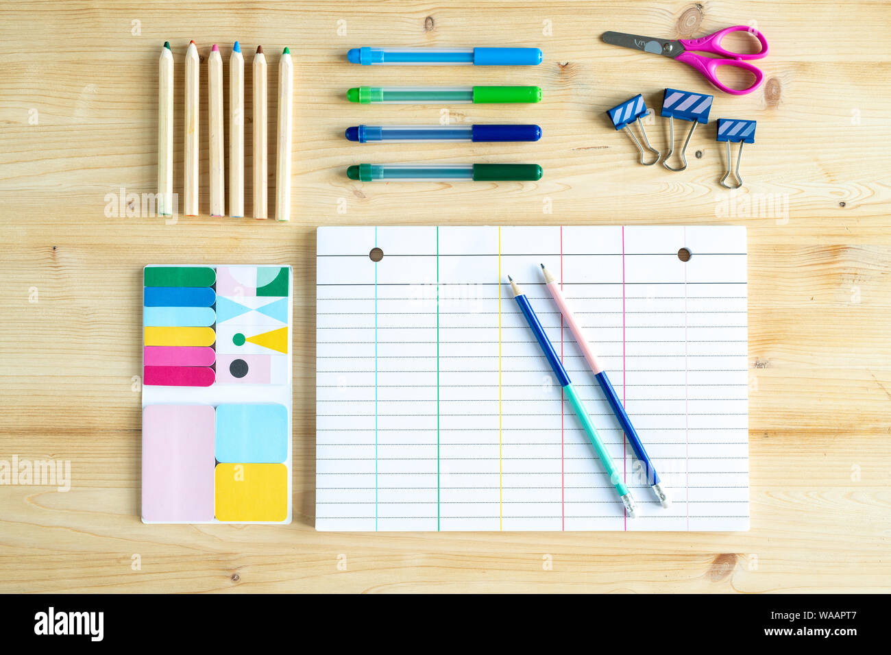 Top view of sheet of paper with lines surrounded by group of office ...