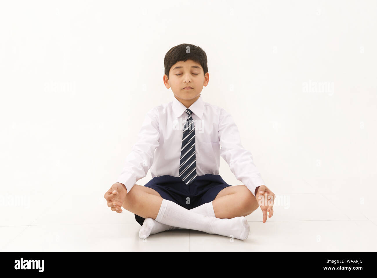 Schoolboy sitting in yoga pose Stock Photo - Alamy