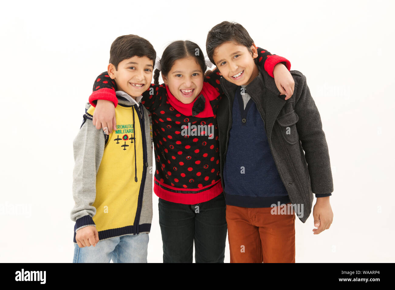 Three friends standing together and smiling Stock Photo - Alamy