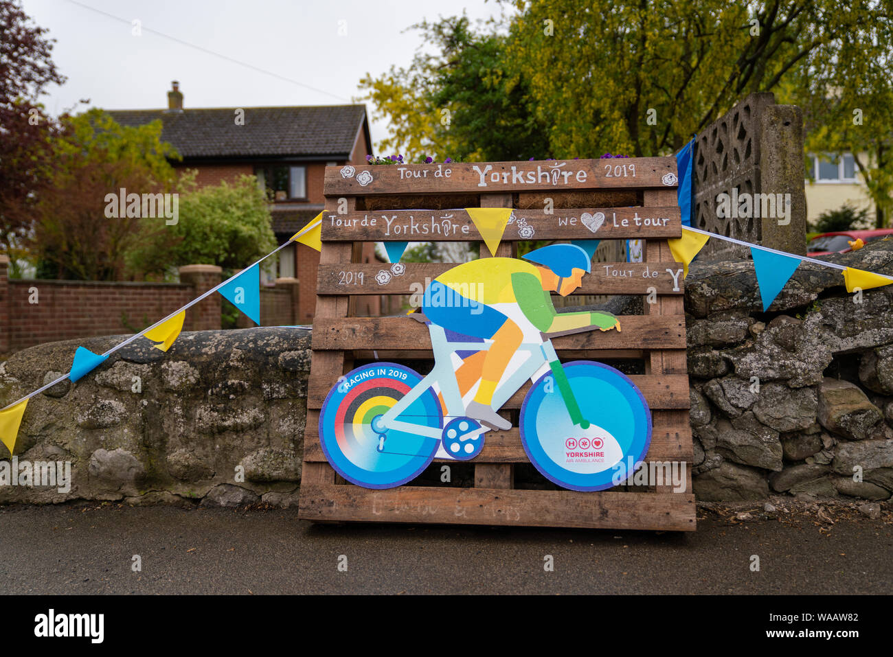 Decal of racing cyclist with blue and yellow bunting supporting cycle ...