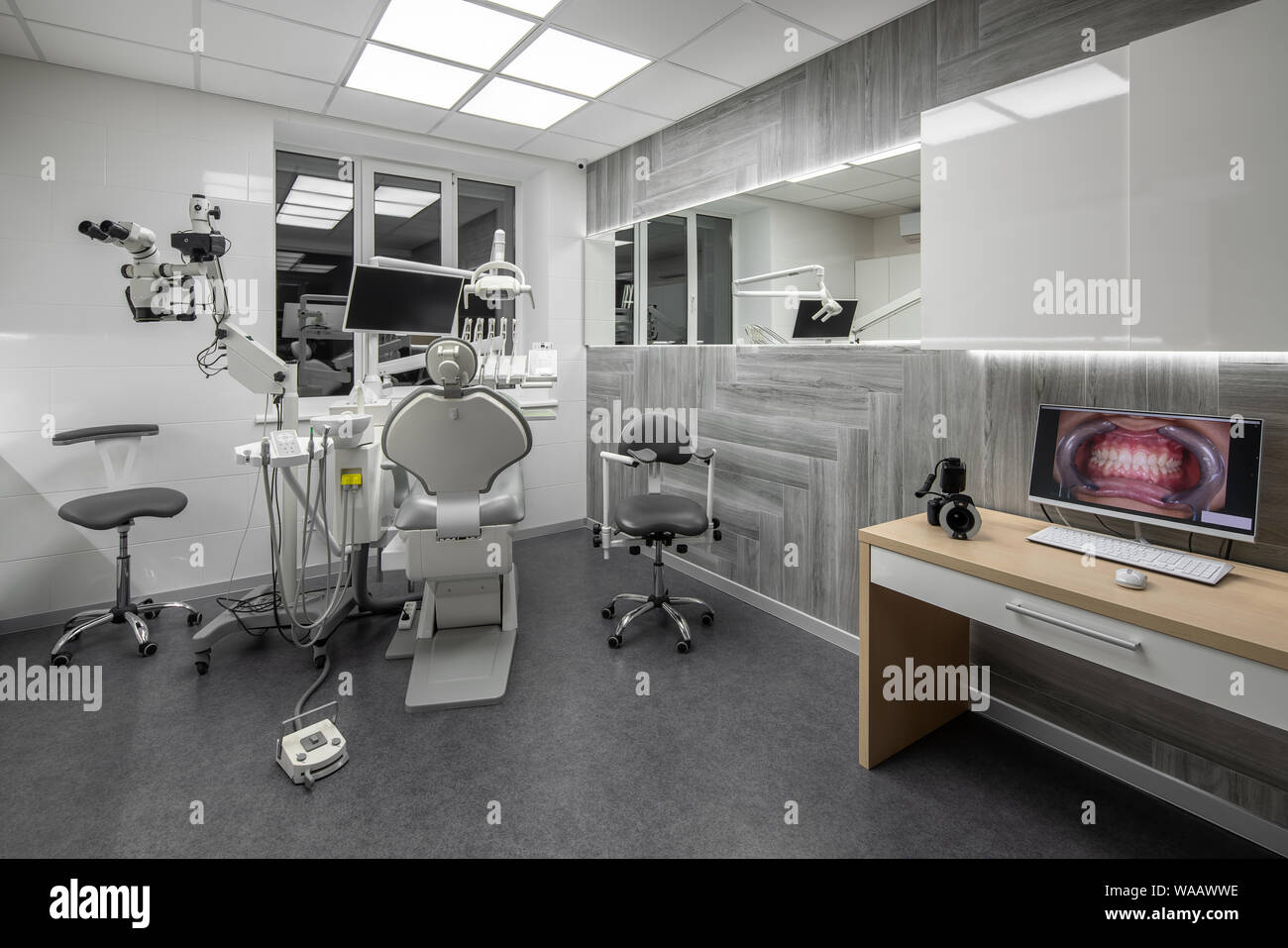 Illuminated room in a dental clinic with light walls and dark gray ...