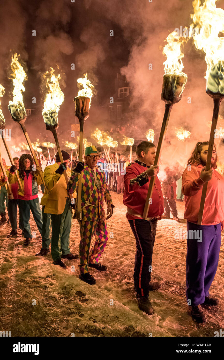Men in colourful fancy dress costumes parade through the snowy streets ...