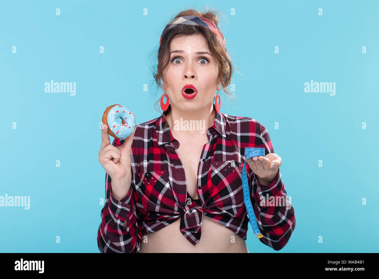 Diet, weight loss and junk food - pin-up woman choosing between dessert ...