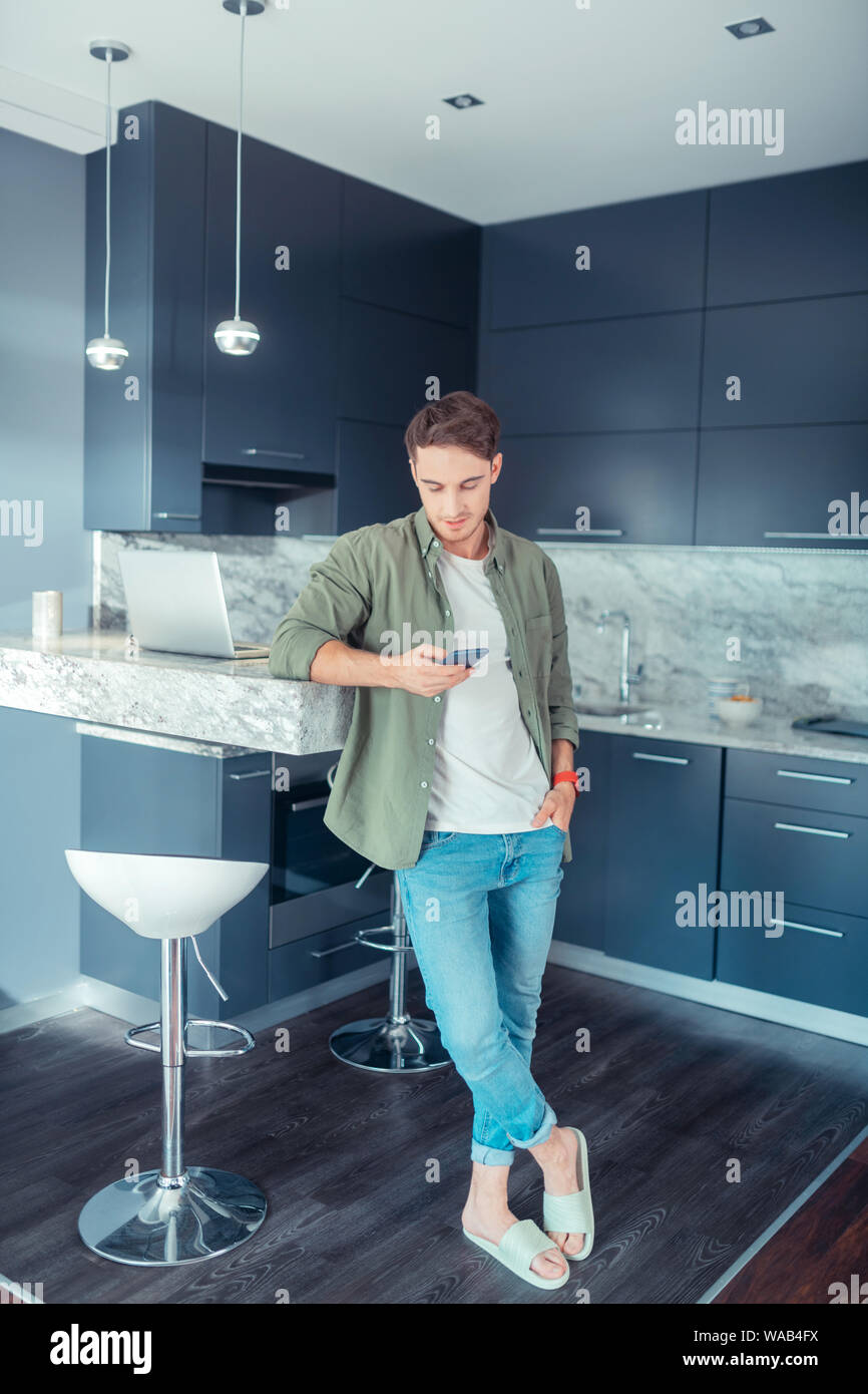 Man standing in his spacious modern kitchen Stock Photo - Alamy