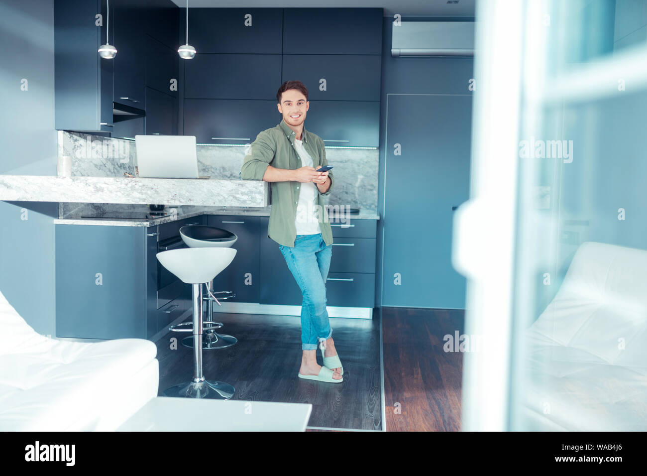 Handsome man standing near table in the kitchen Stock Photo - Alamy