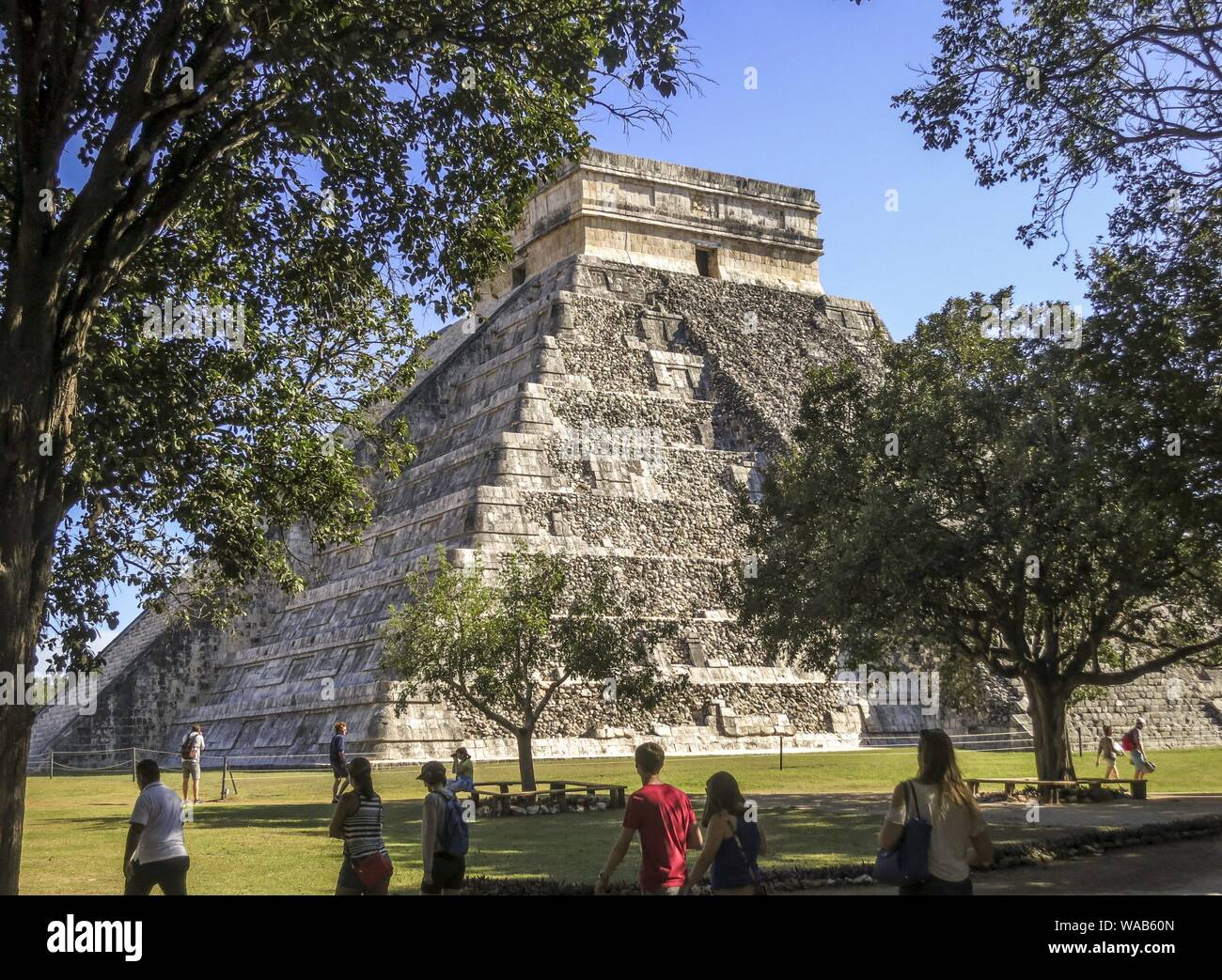 Tourists walk in front of the impressive pyramid in the ruined city of ...