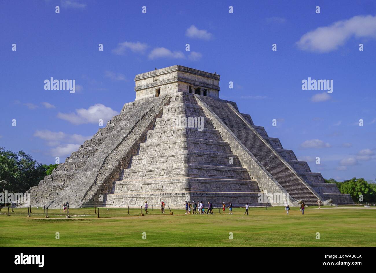 Tourists walk in front of the impressive pyramid in the ruined city of ...