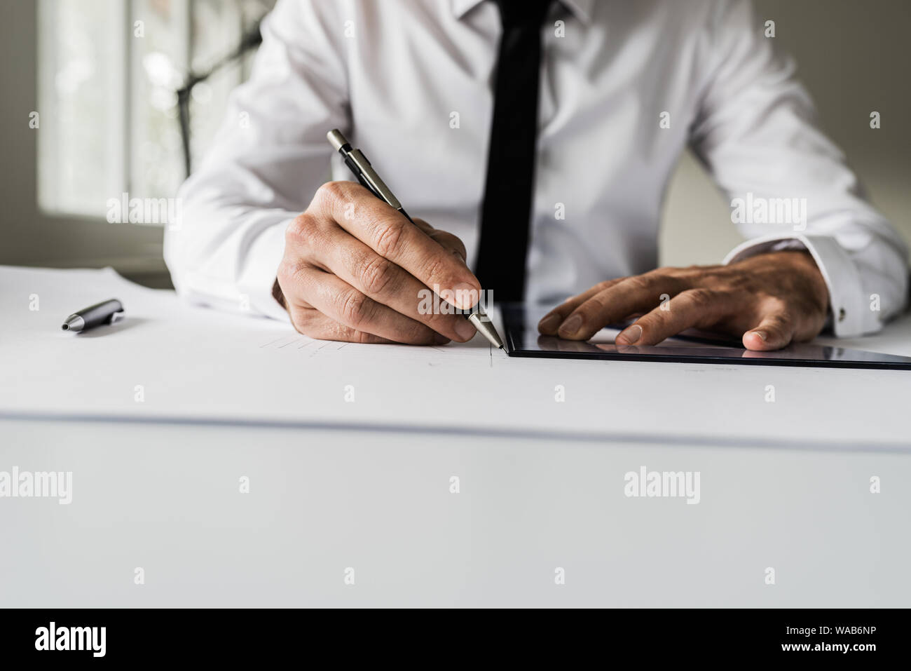 Front view of architect or designer working on a project drawing using ...