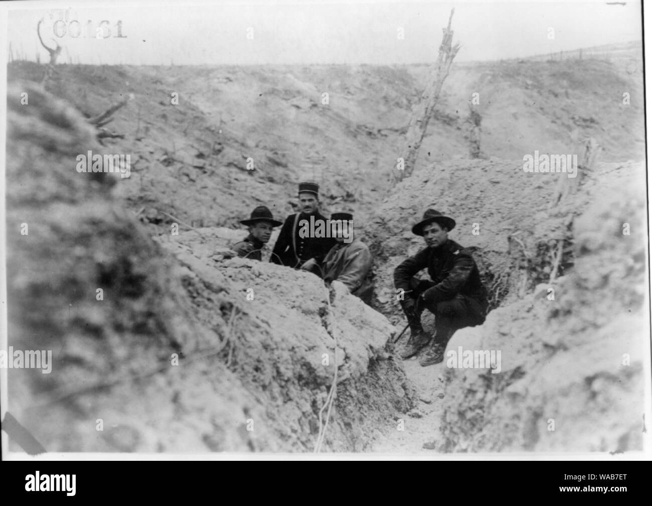 Col. William Mitchell sitting in a shallow trench with three ...