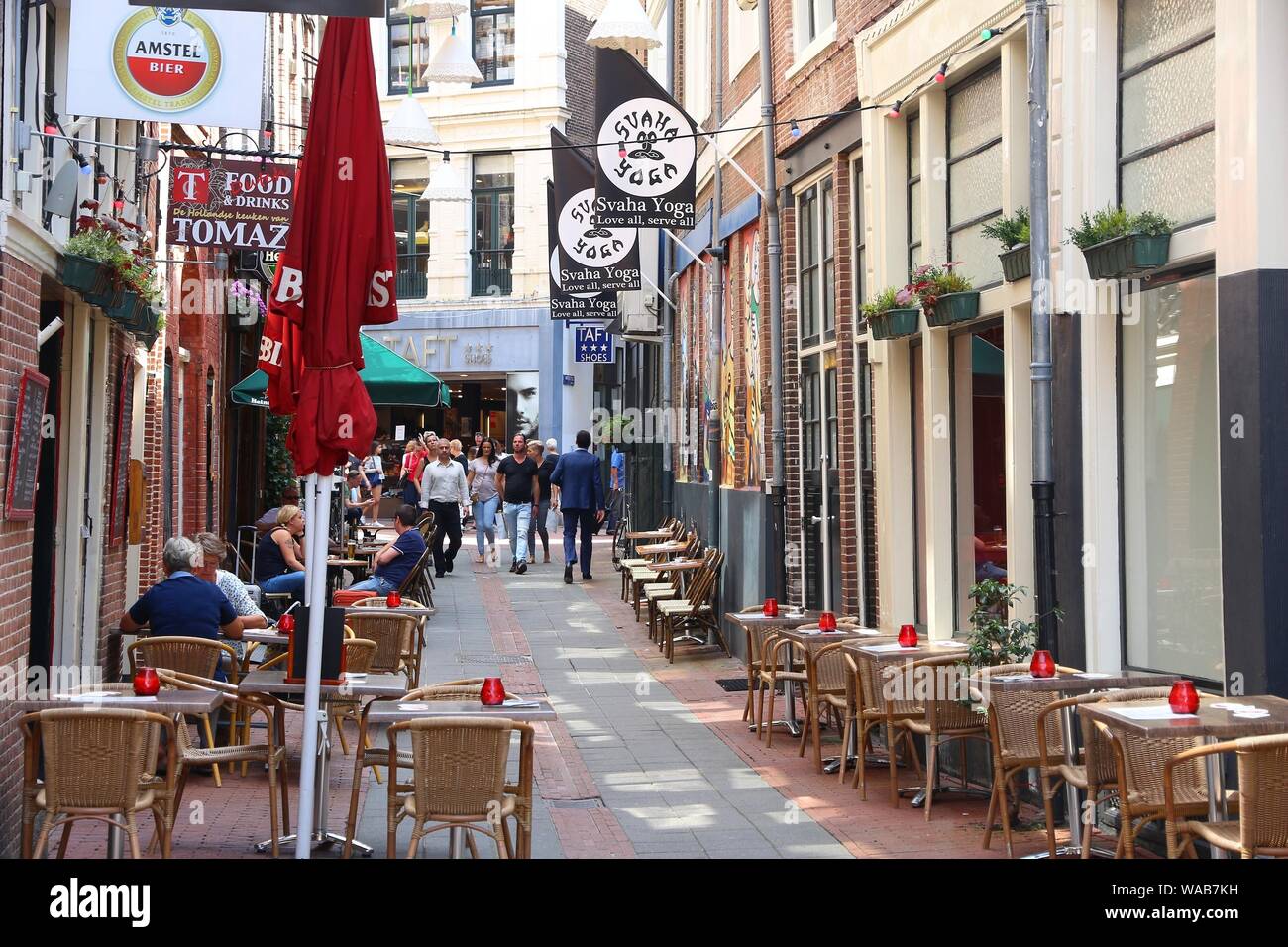 AMSTERDAM, NETHERLANDS - JULY 10, 2017: People visit shops and cafes in ...