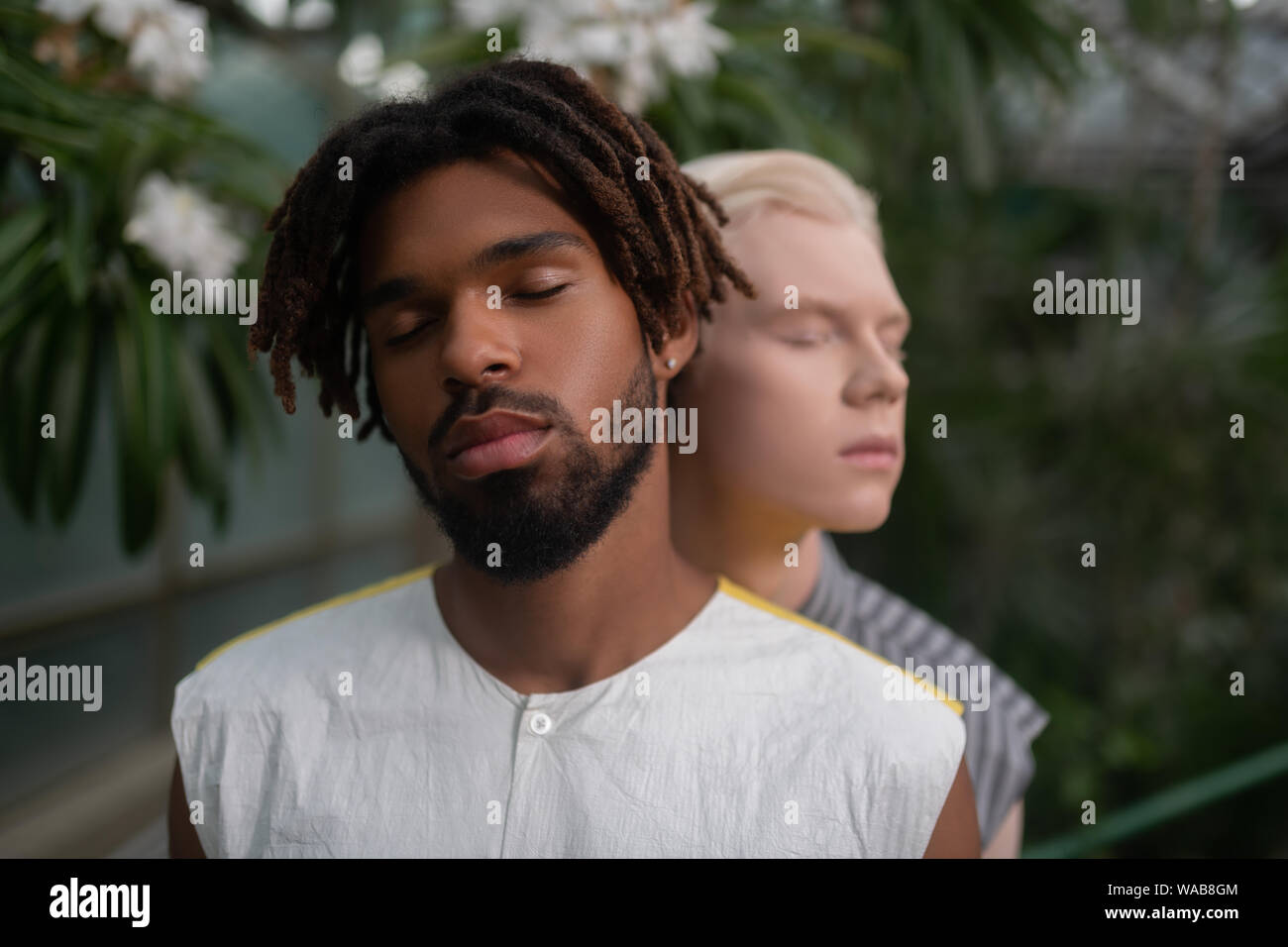 Models closing eyes while participating in photo session Stock Photo ...