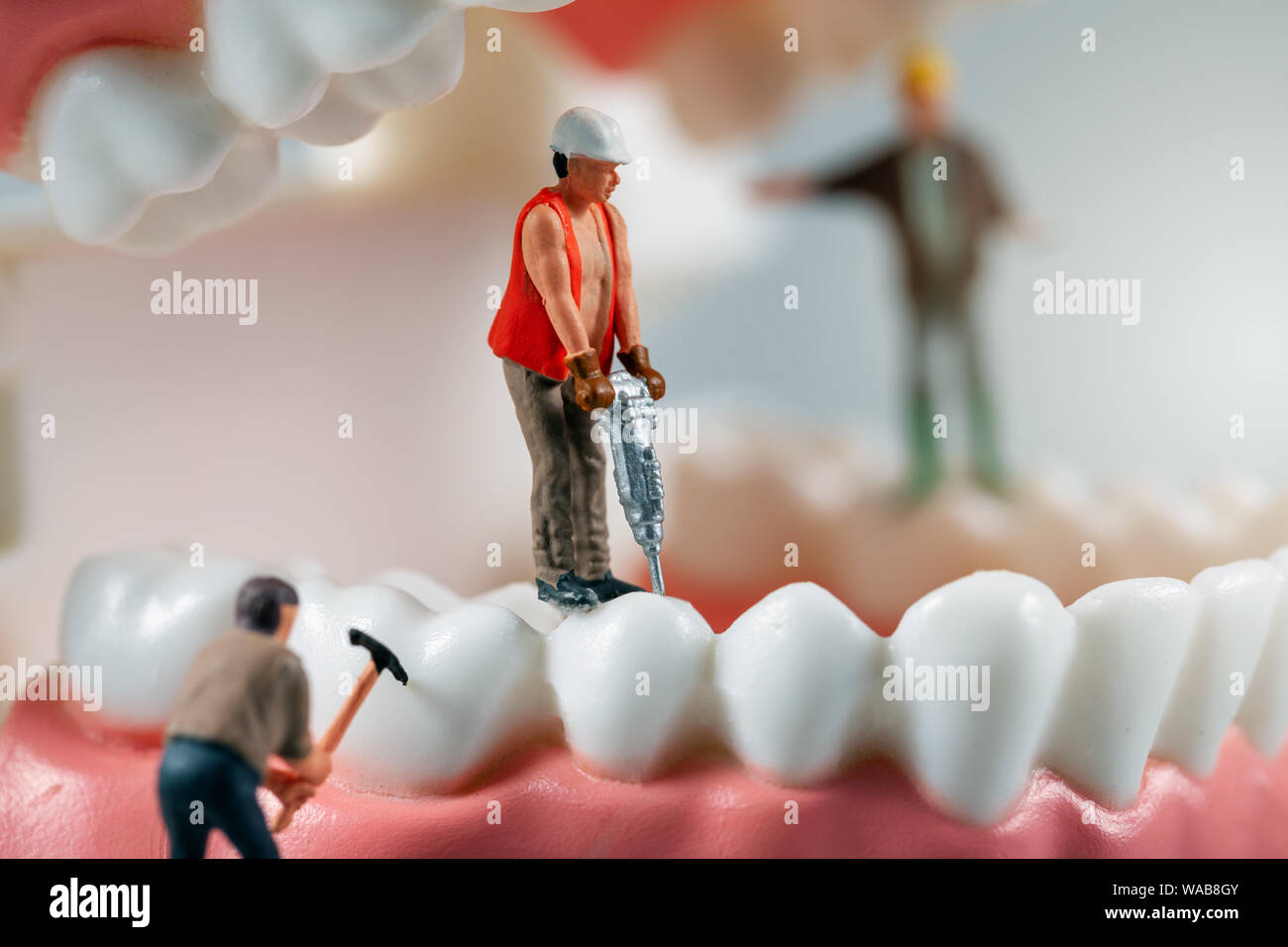 dental treatment concept - miniature figurines of construction workers ...