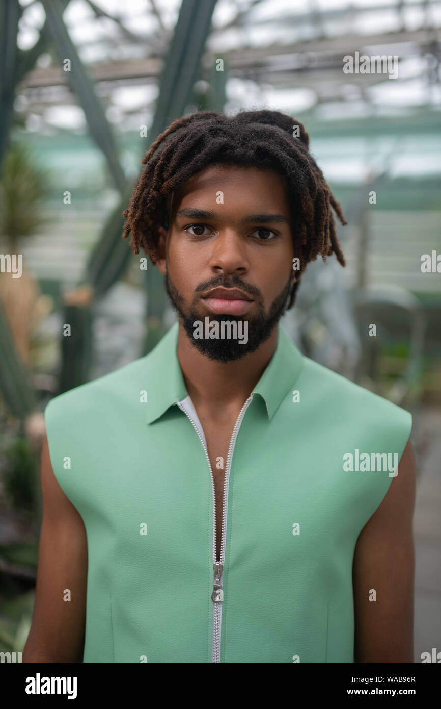 Bearded male model with dreadlocks standing in greenhouse Stock Photo ...
