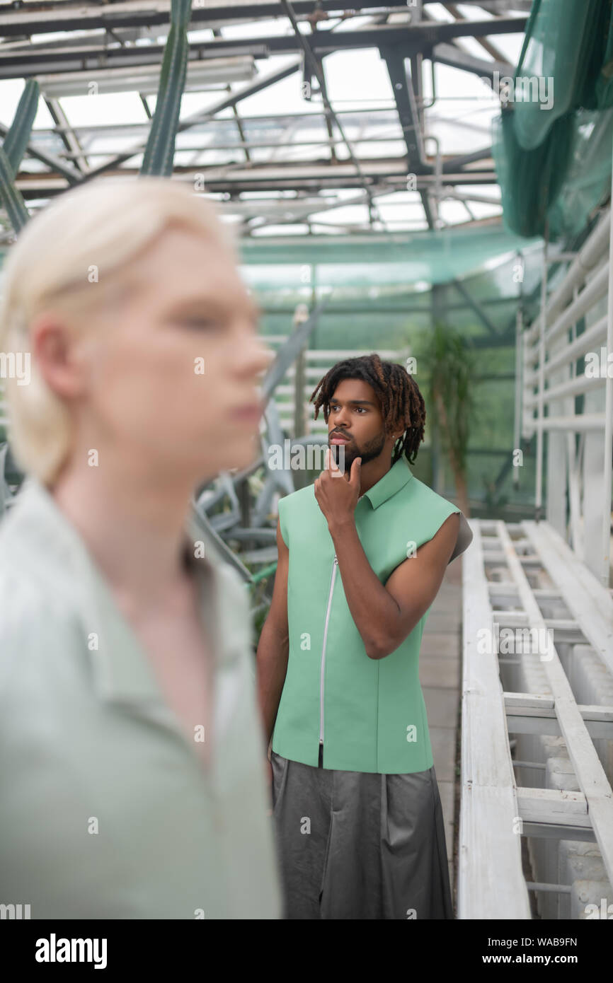 Models wearing grey shorts posing in greenhouse Stock Photo - Alamy