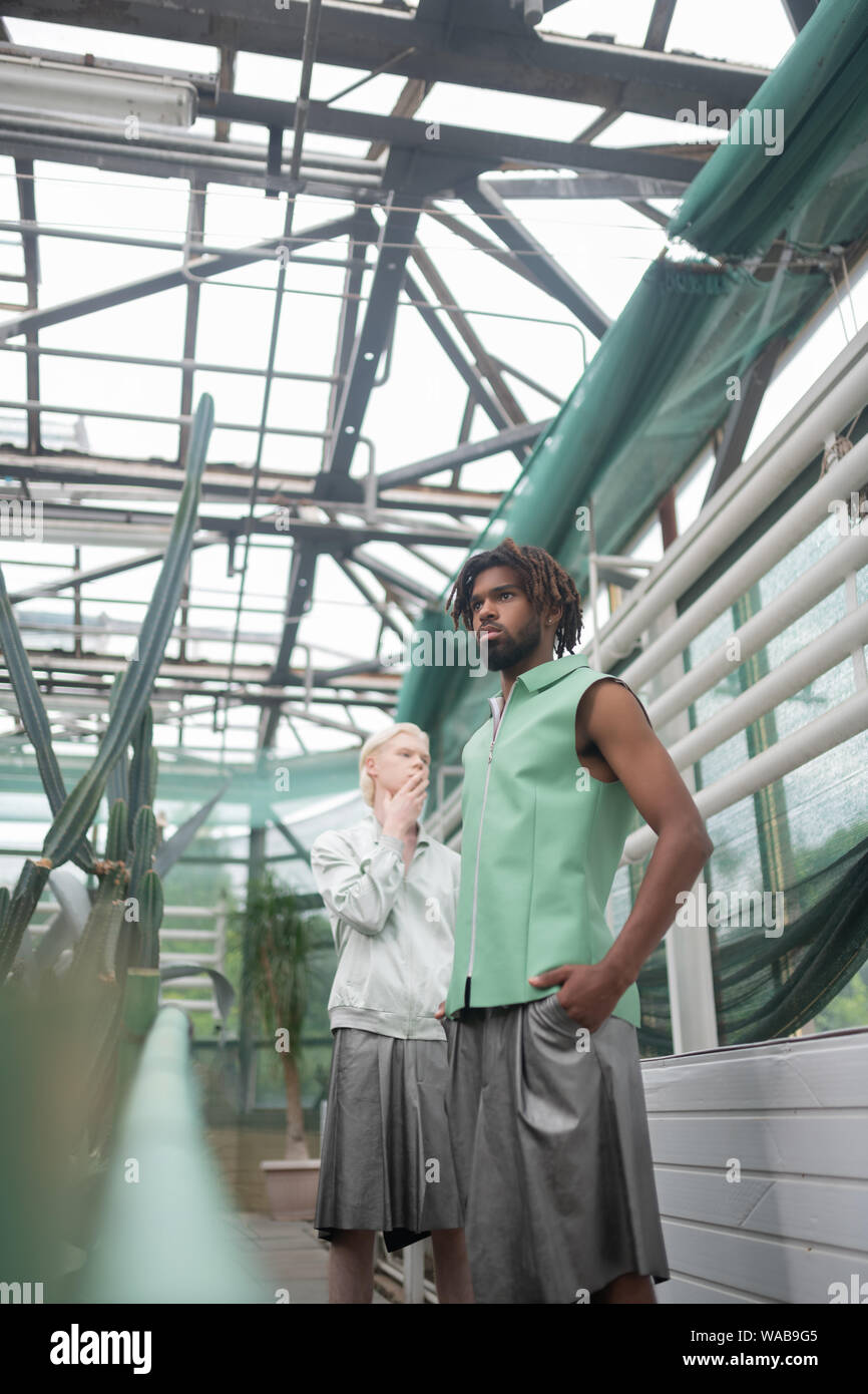Serious models wearing grey shorts posing in greenhouse Stock Photo - Alamy