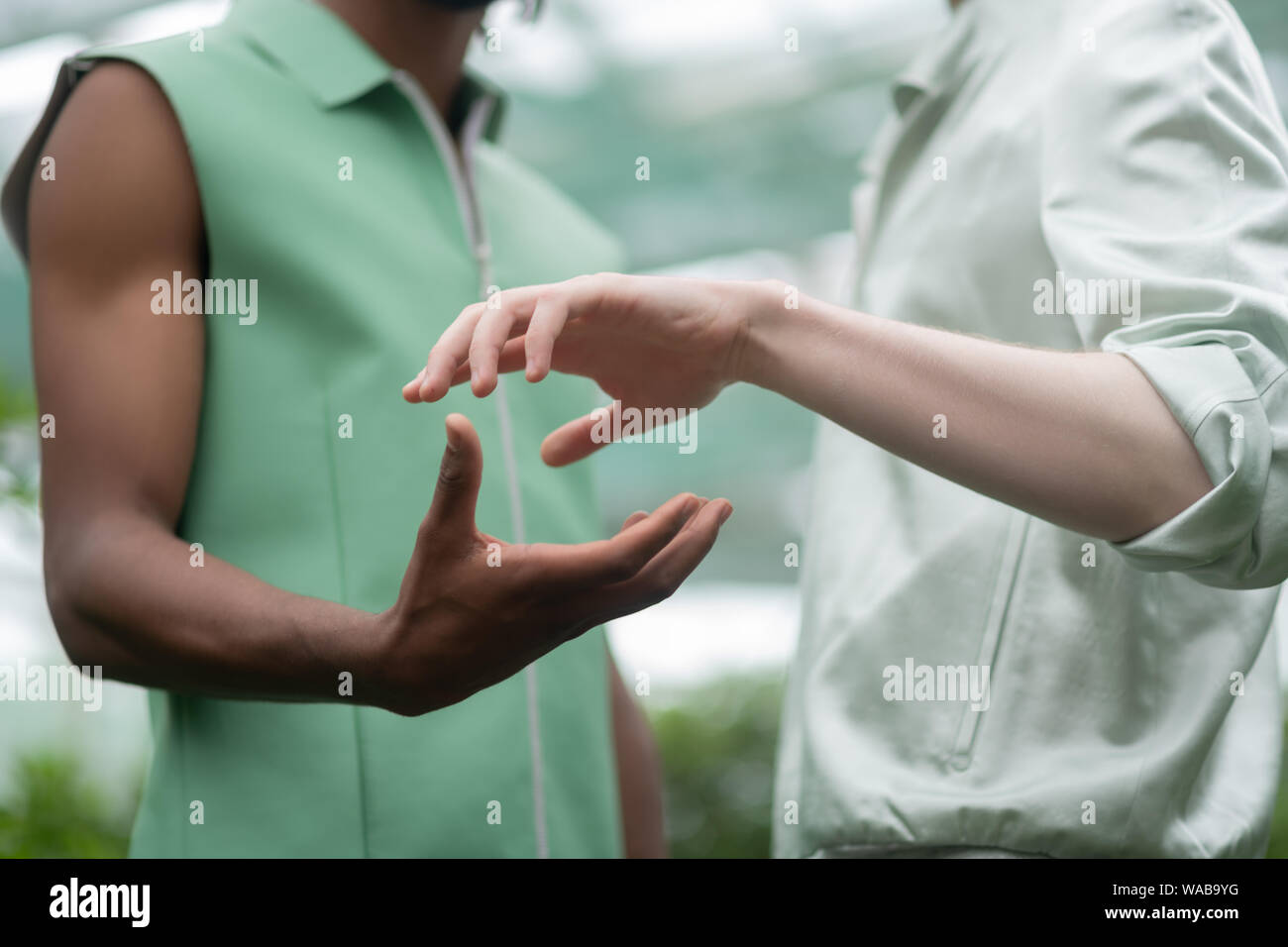 Models standing and posing while almost touching hands Stock Photo - Alamy