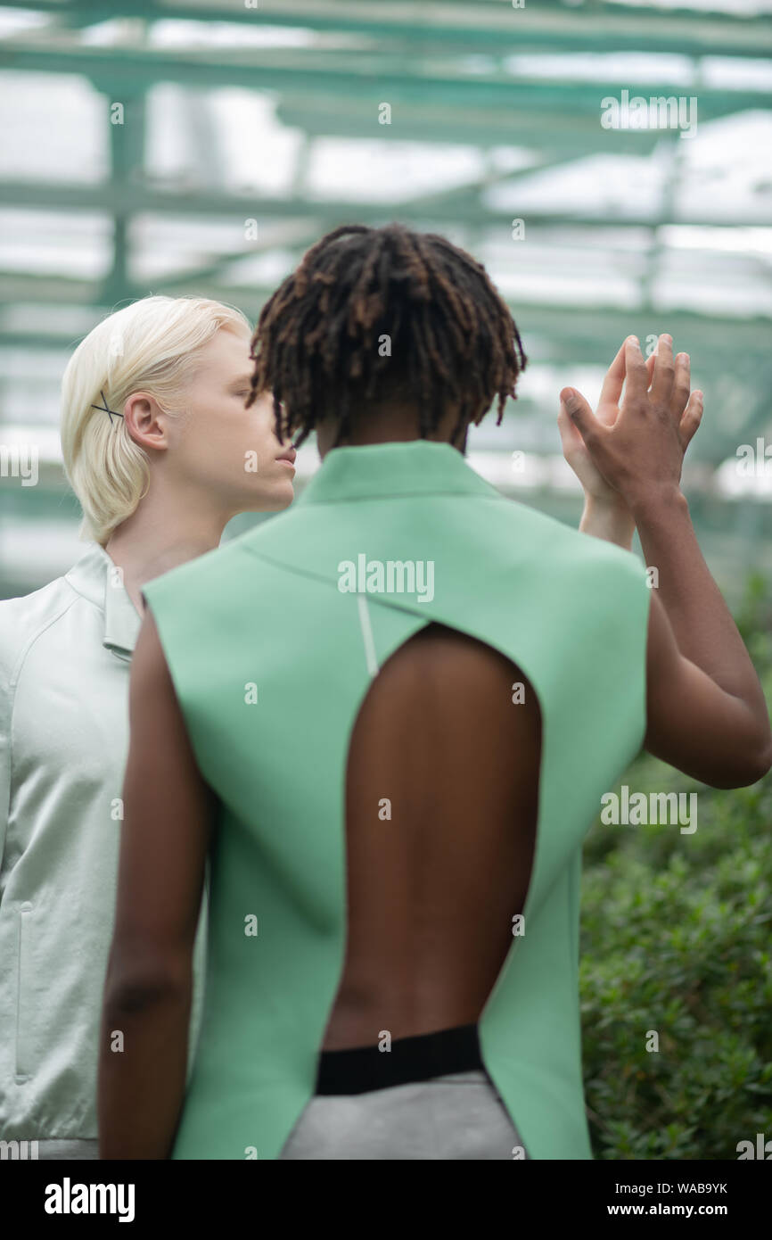 Dark-skinned man with open back standing near man Stock Photo - Alamy