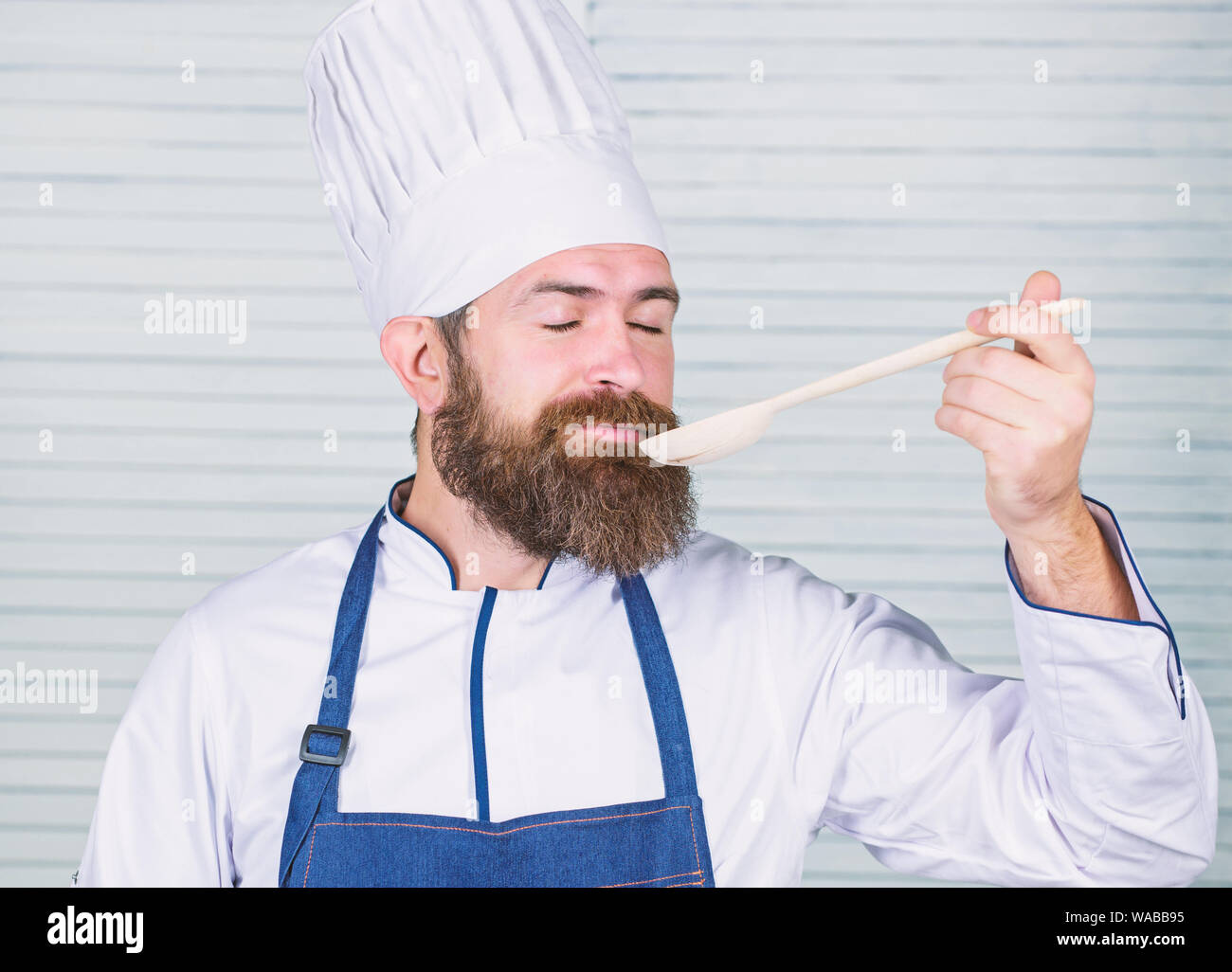 man chef taste soup from wooden spoon. Cuisine culinary. Vitamin ...