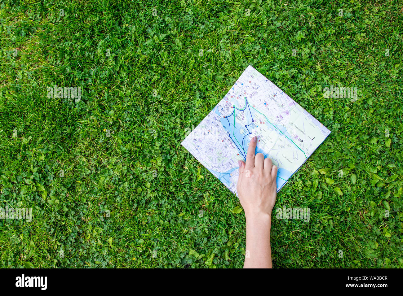 Travel on the map. Female hand shows a finger on a topographic map on ...