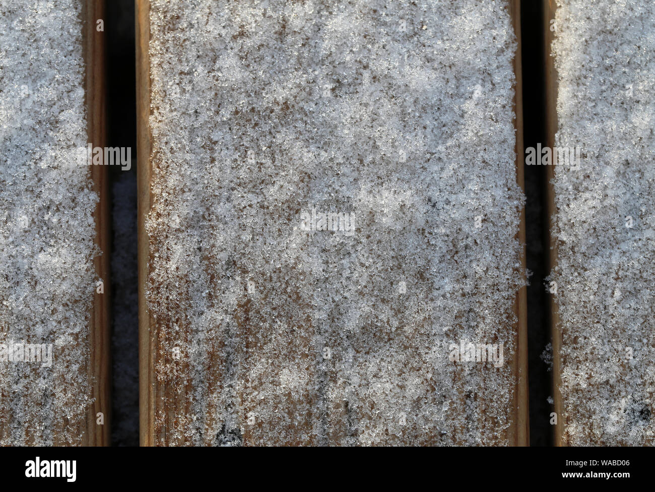 Surface of a wooden balcony floor with some fresh snow and ice on top ...