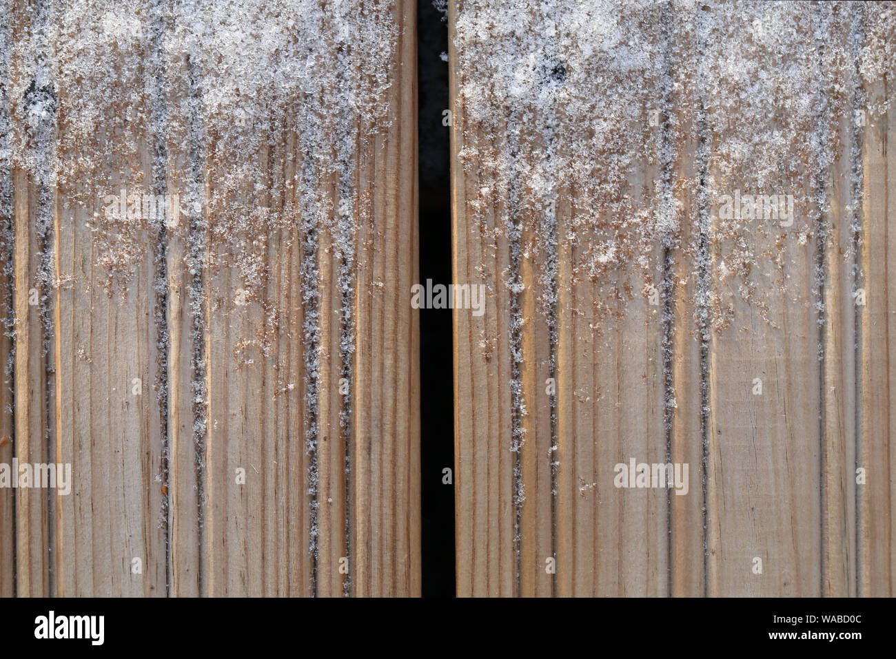 Surface of a wooden balcony floor with some fresh snow and ice on top ...