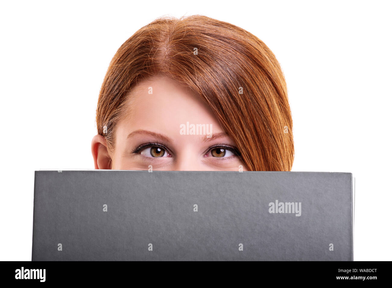 Close up shot of a young female student hiding her face behind a ...