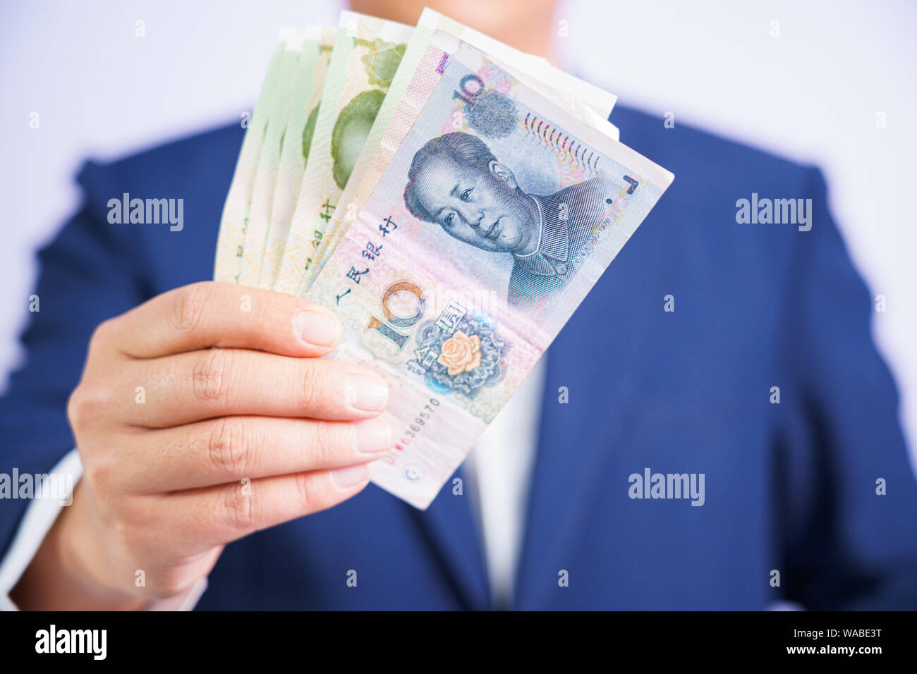 Money in China hold on hand business man wearing a blue suit CNY, Pay ...