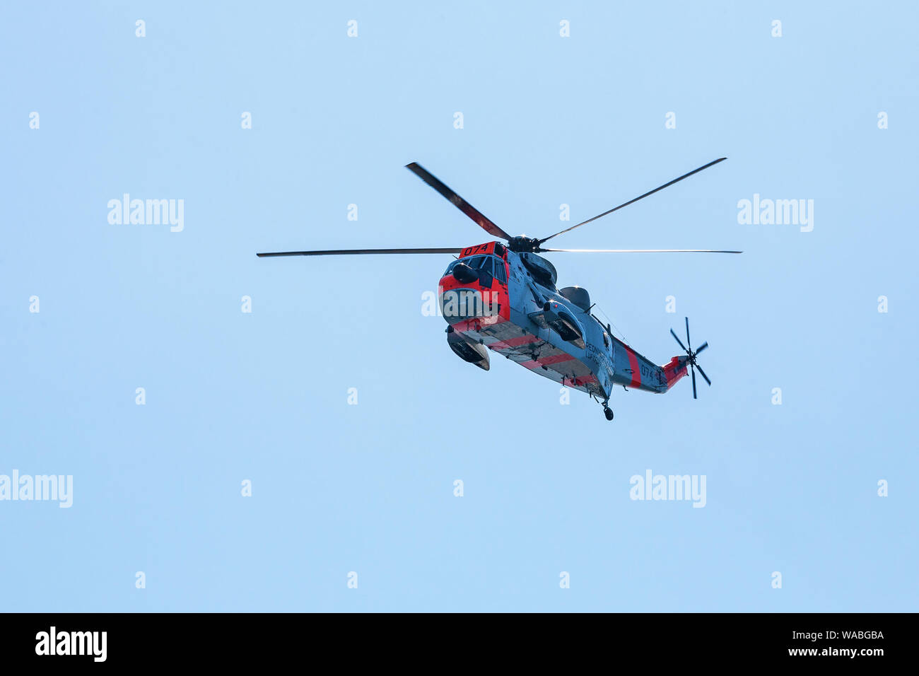 Rescue helicopter flying in the blue sky Stock Photo - Alamy