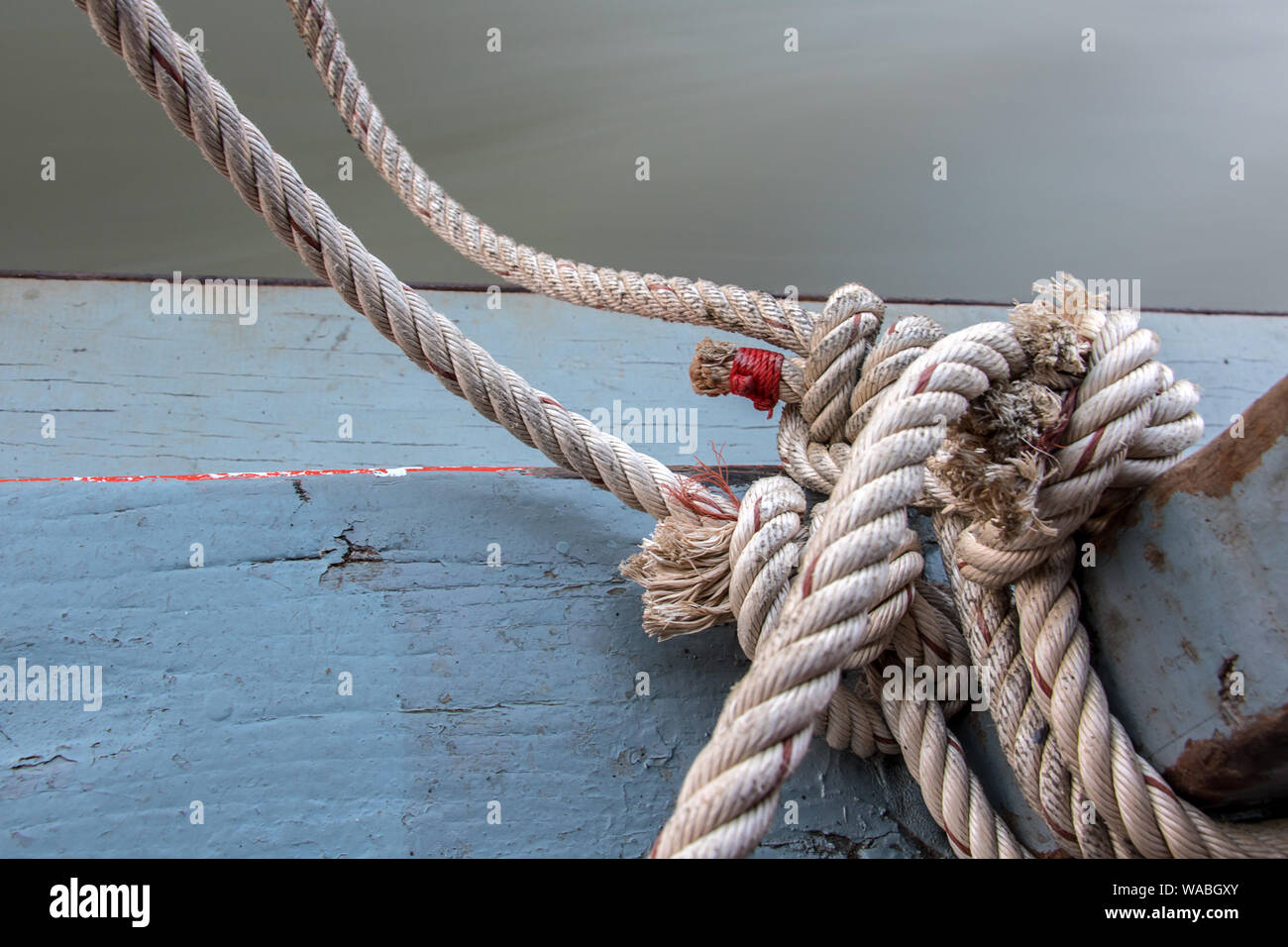Boat rope tied to a wooden post on a floating boat railing, close up ...