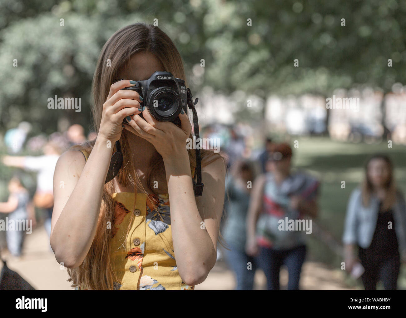 Photographer girl taking pictures with canon camera Stock Photo - Alamy