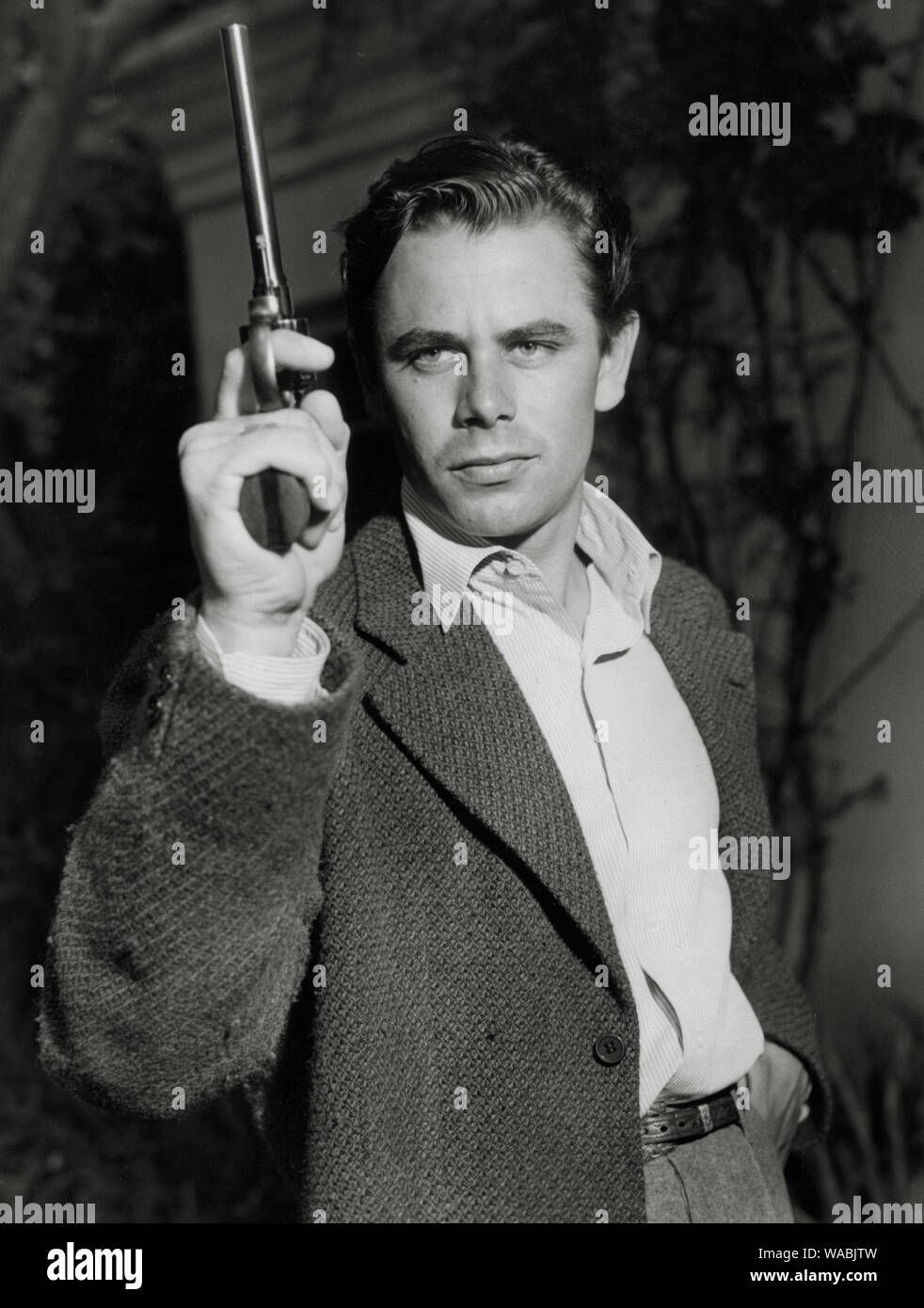 Glenn Ford holding a revolver gun, circa 1945 File Reference # 33848 ...