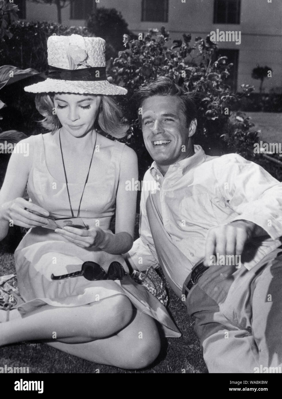 Leslie Caronwears a hat and shows George Peppard photographs of her ...