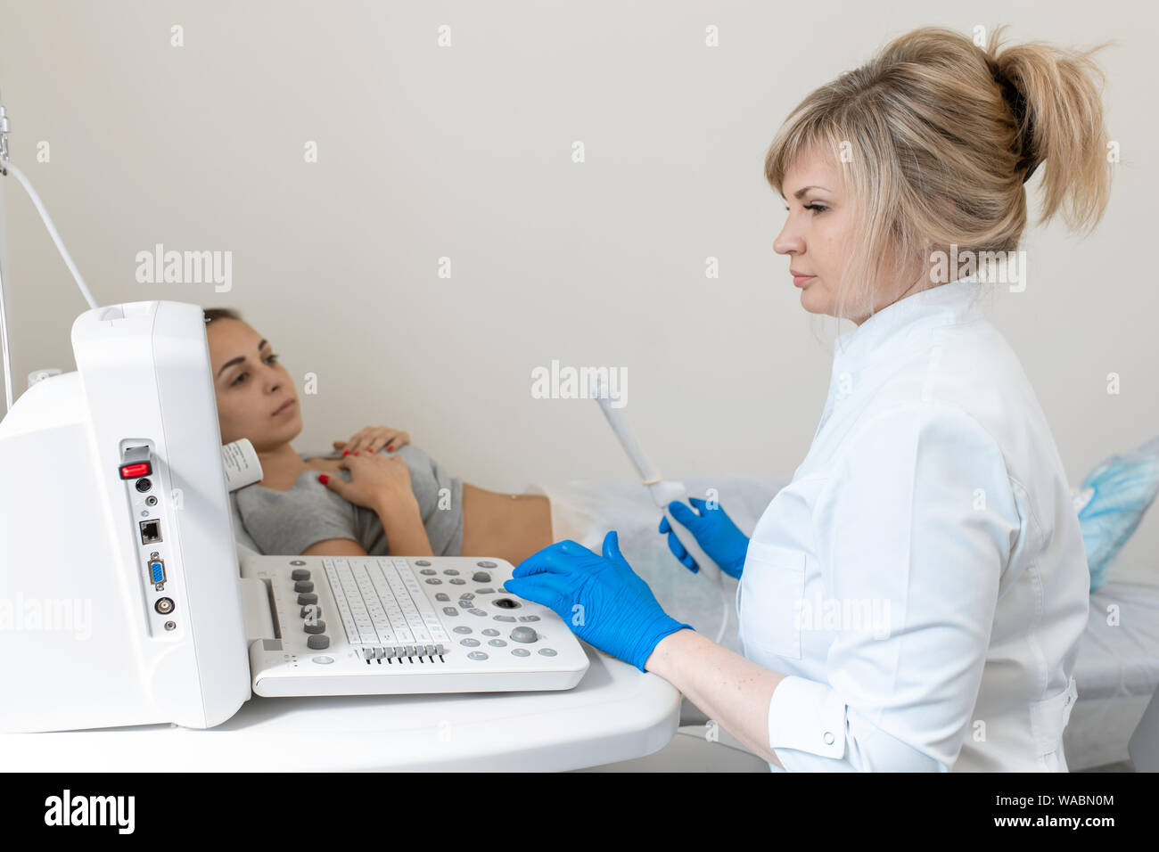 The gynecologist sets up the ultrasound machine and explains to the ...