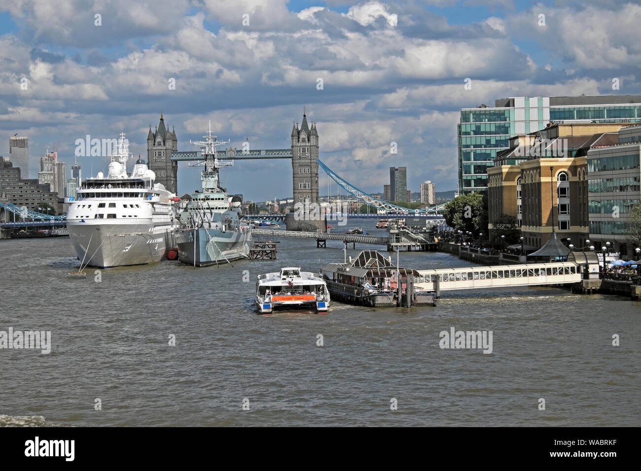 View of Tower Bridge ships and tourist boats on the River Thames on a ...