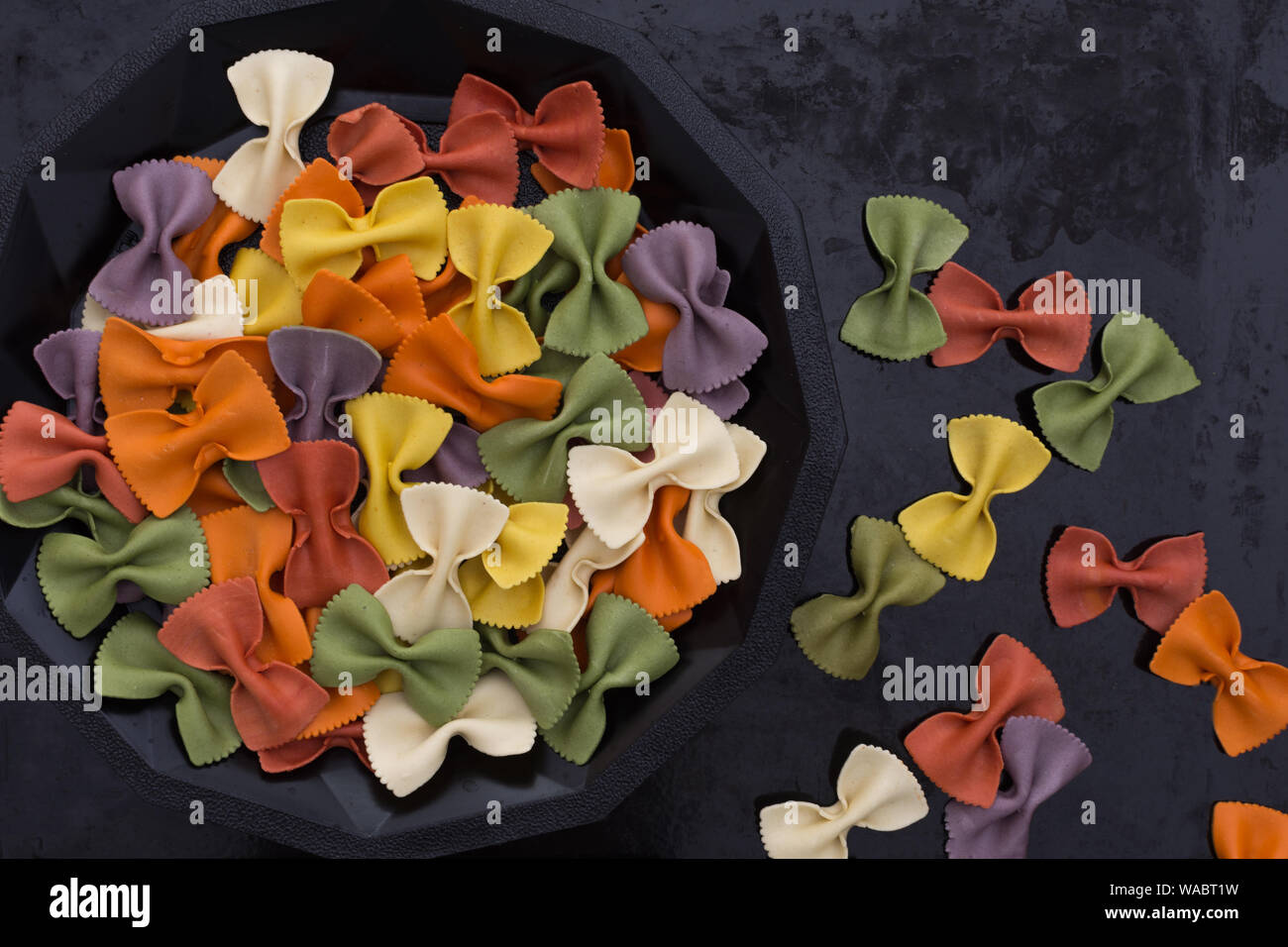 Italian raw multicolored farfalle pasta close-up on black background ...