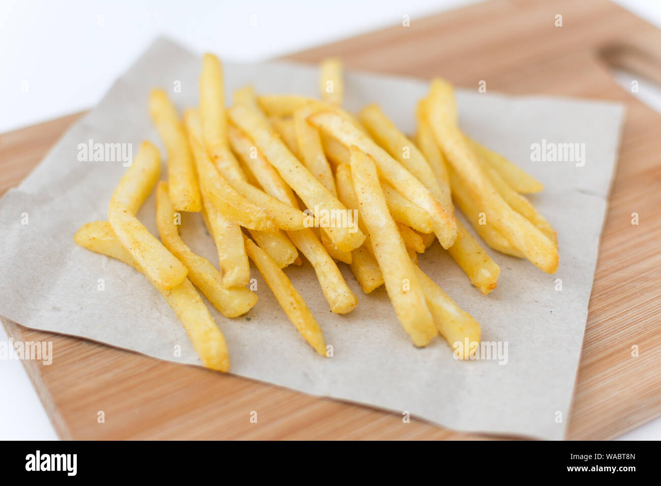French fried potatoes on cutting board top view. Tasty french fries ...