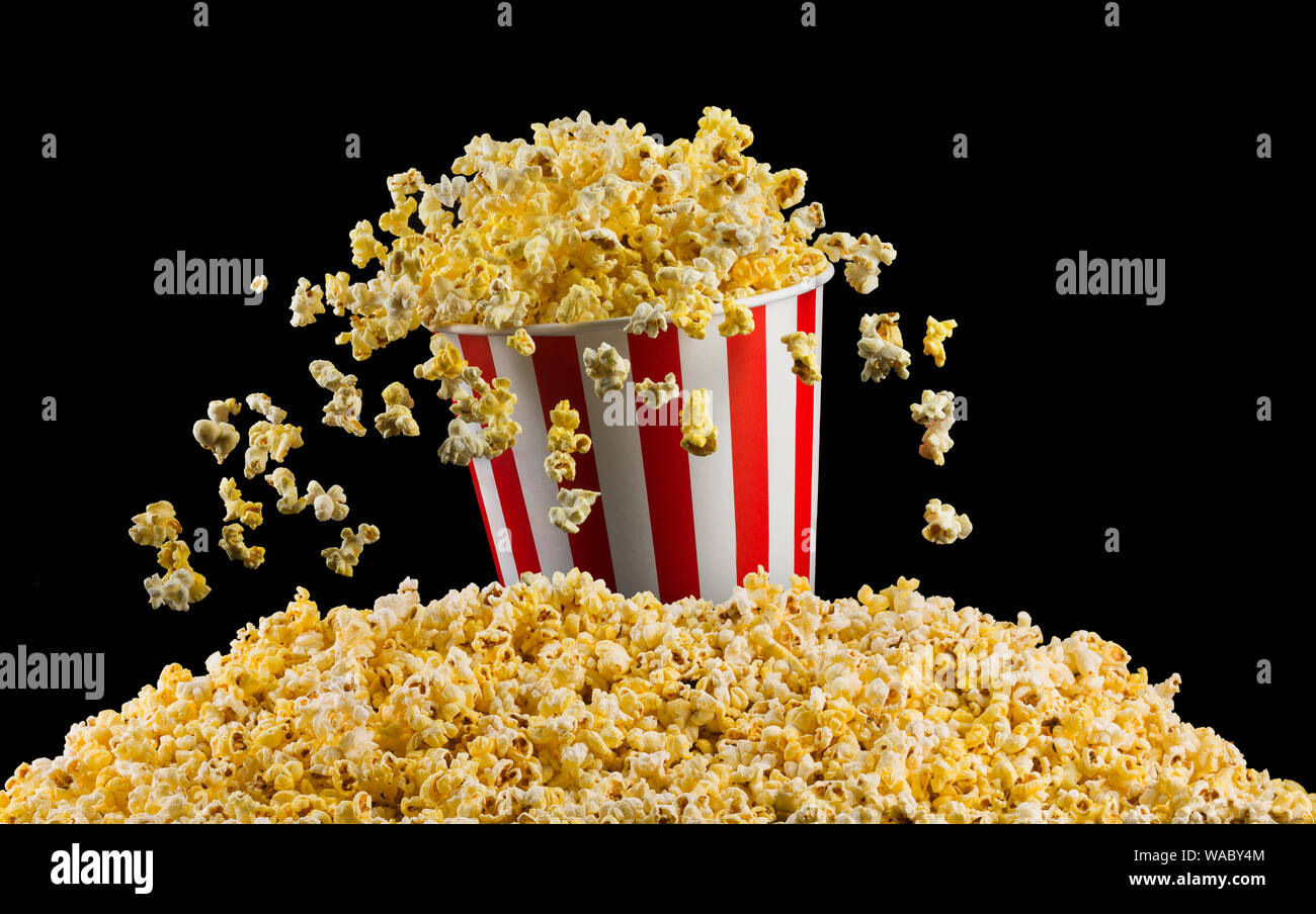 Flying popcorn from striped bucket isolated on black background Stock ...