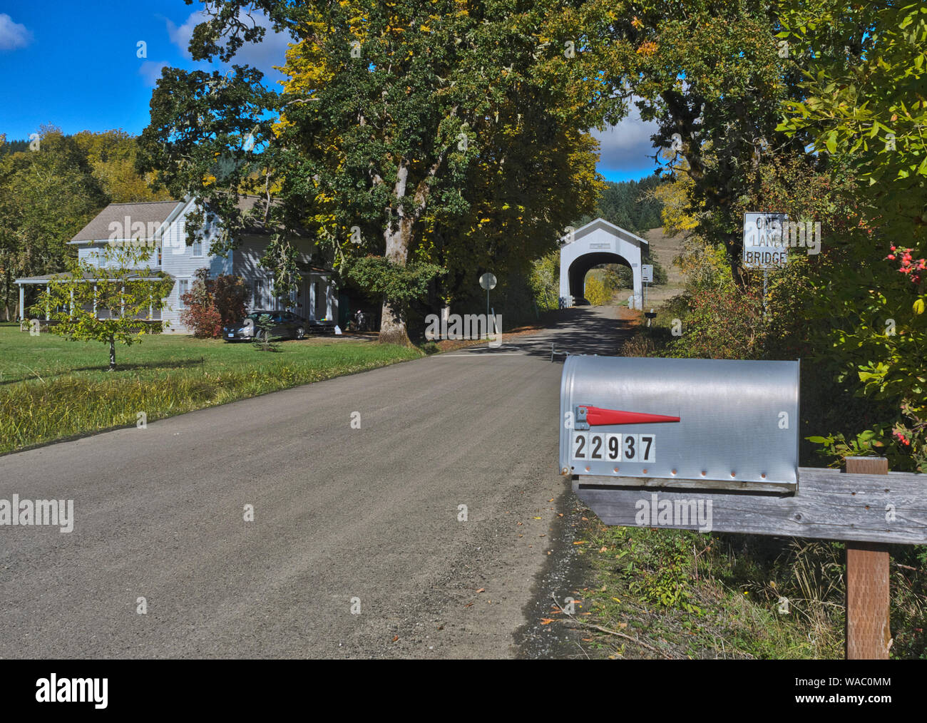 A rural mailbox and farmhouse sit in front of Harris Covered Bridge ...