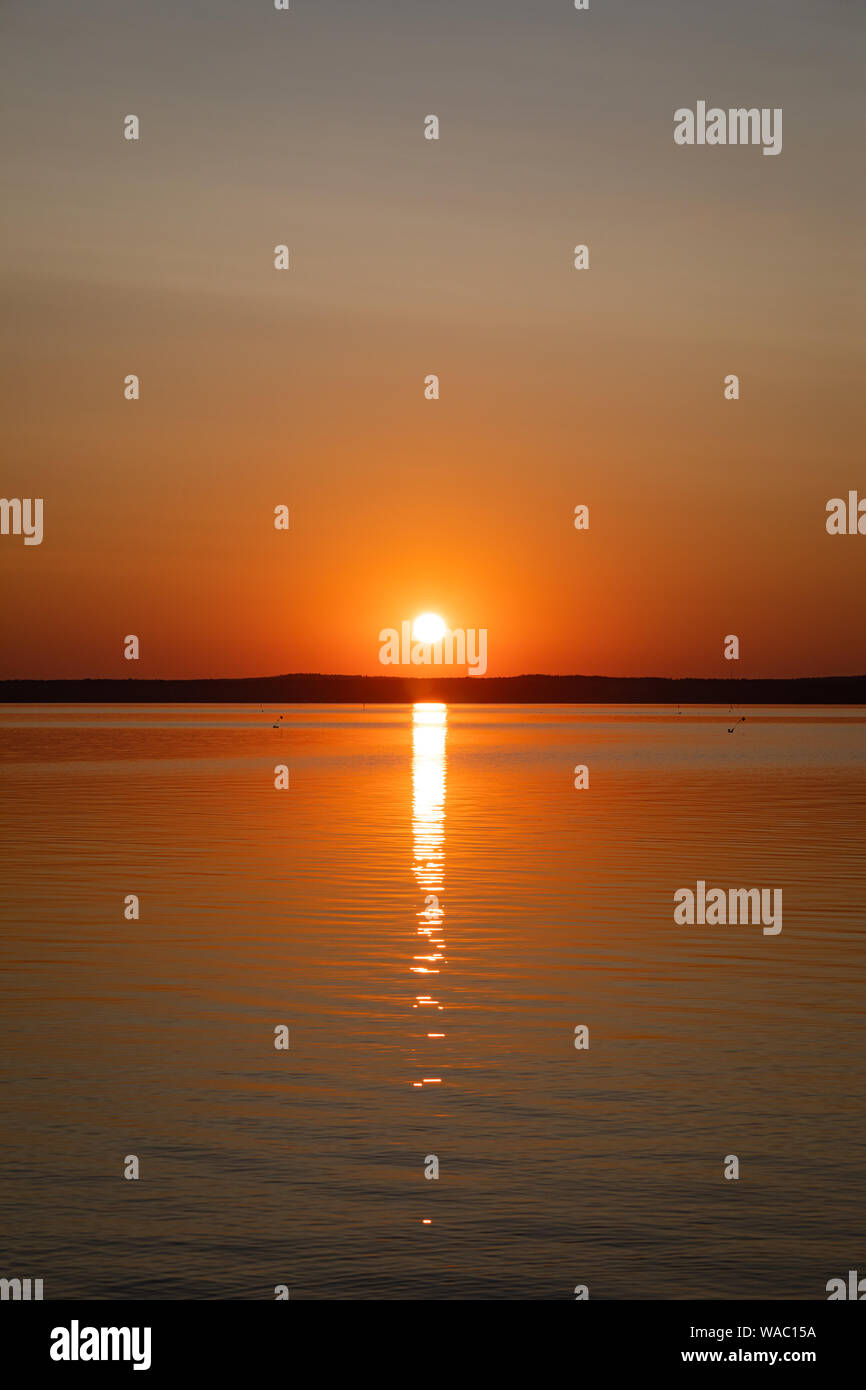 Sunrise above horizon forest at lake Stock Photo - Alamy