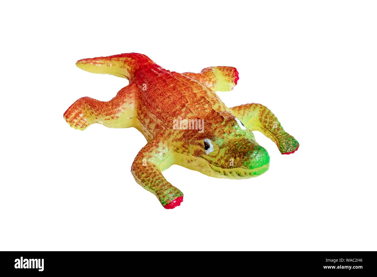 A soft plastic toy crocodile or alligator isolated against a white ...