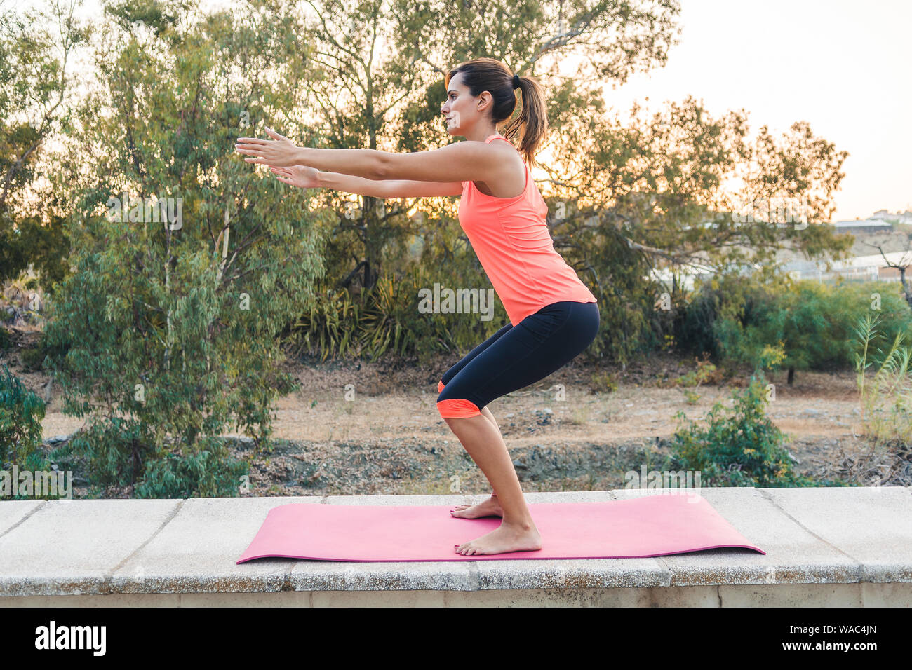 Fitness young woman doing squats in the park. Fitness and yoga concept ...