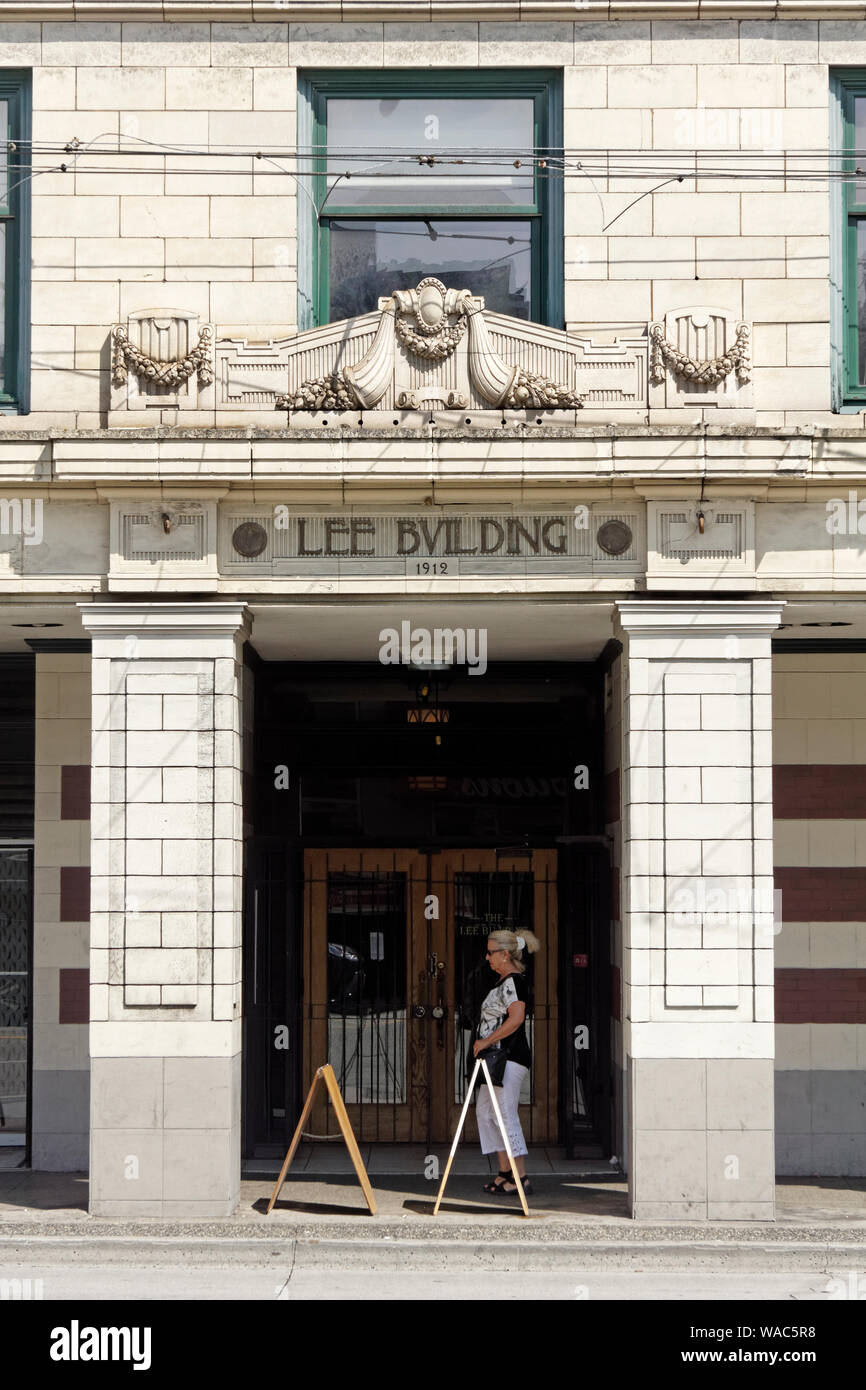 Woman standing in entrance to the Lee Building constructed in 1912 in ...