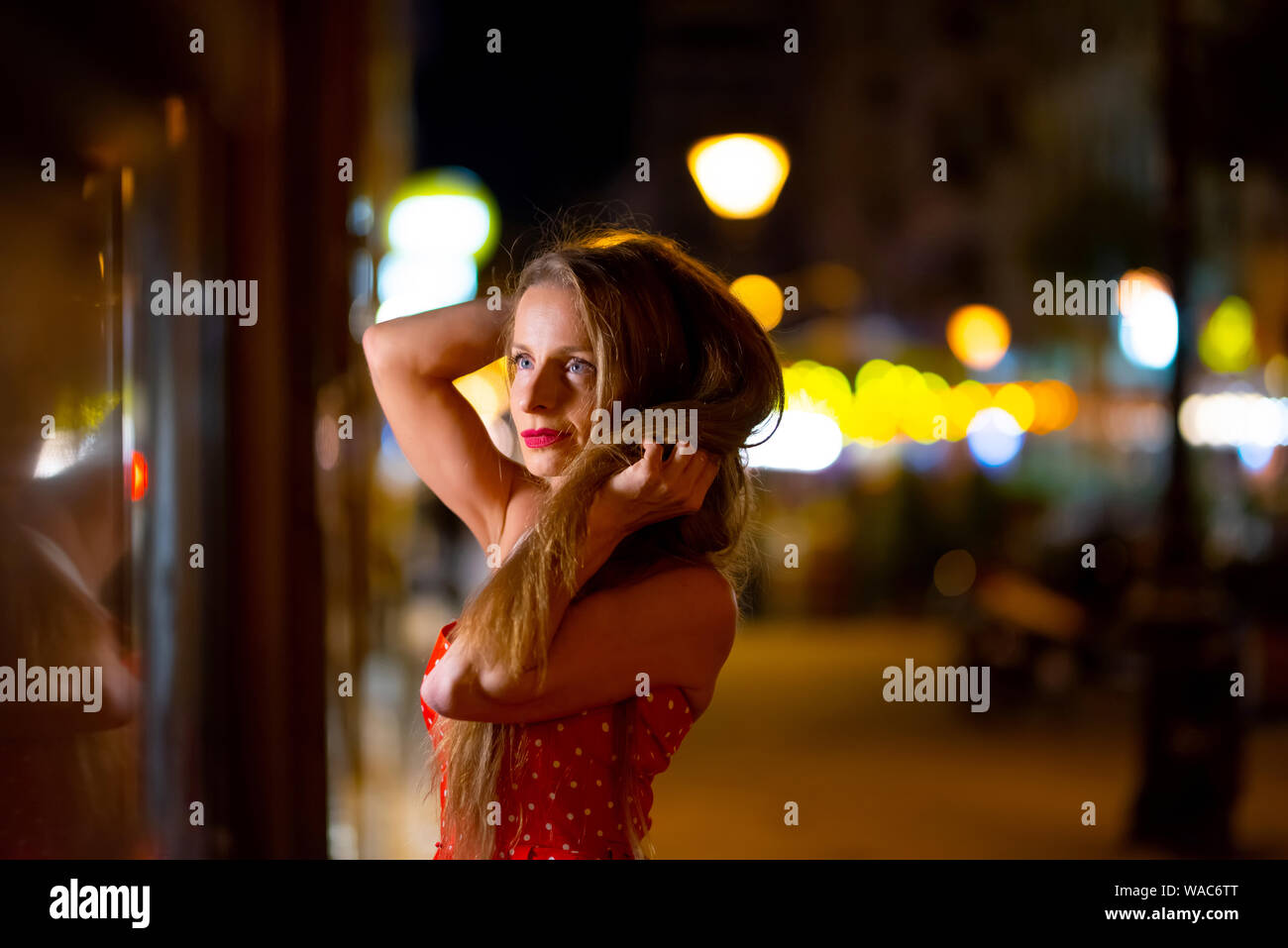Portrait of a beautiful mature woman in a red dress while checking the ...
